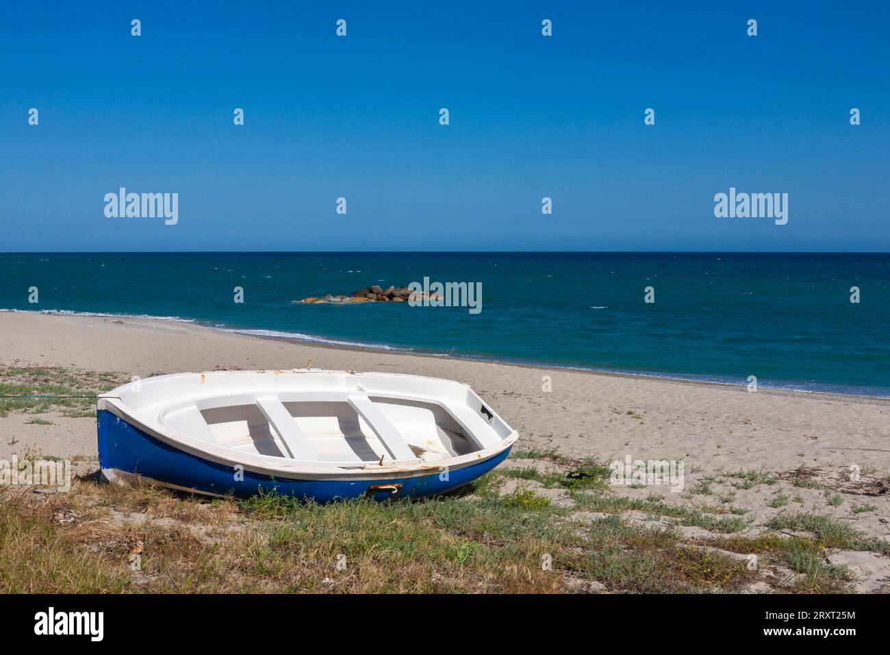 A small boat ashore on the deserted beach at Roccella Ionica, Calabria ...