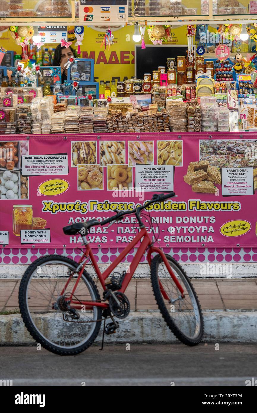 bicycle parked at the roadside outside of a very colourful sweet shop ...