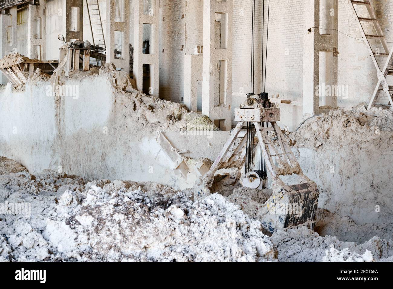 Grabber bucket operates at warehouse in pile of chalk Stock Photo - Alamy