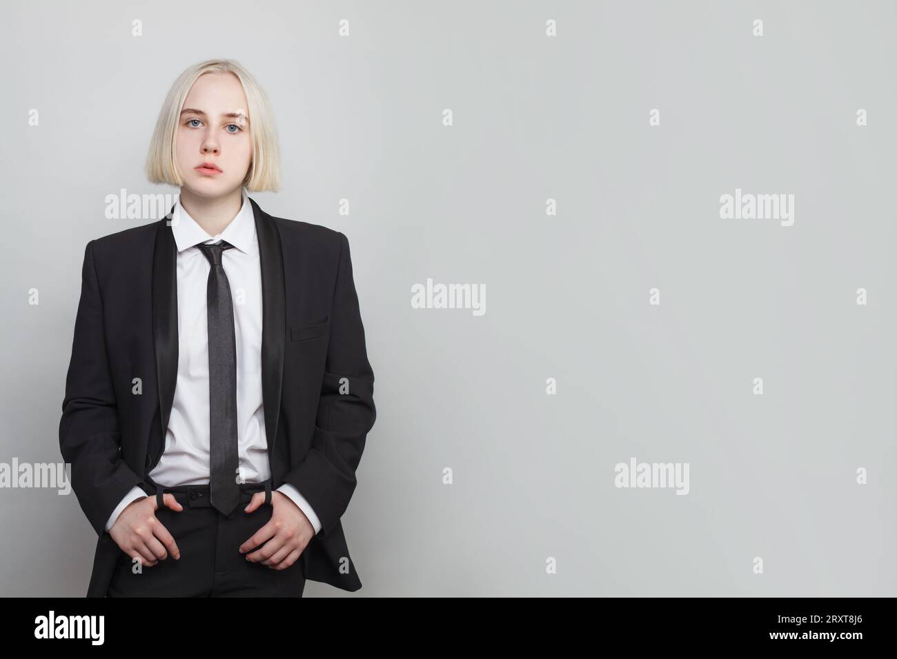 Gorgeous woman with blonde bob hairstyle posing in black suit and tie ...