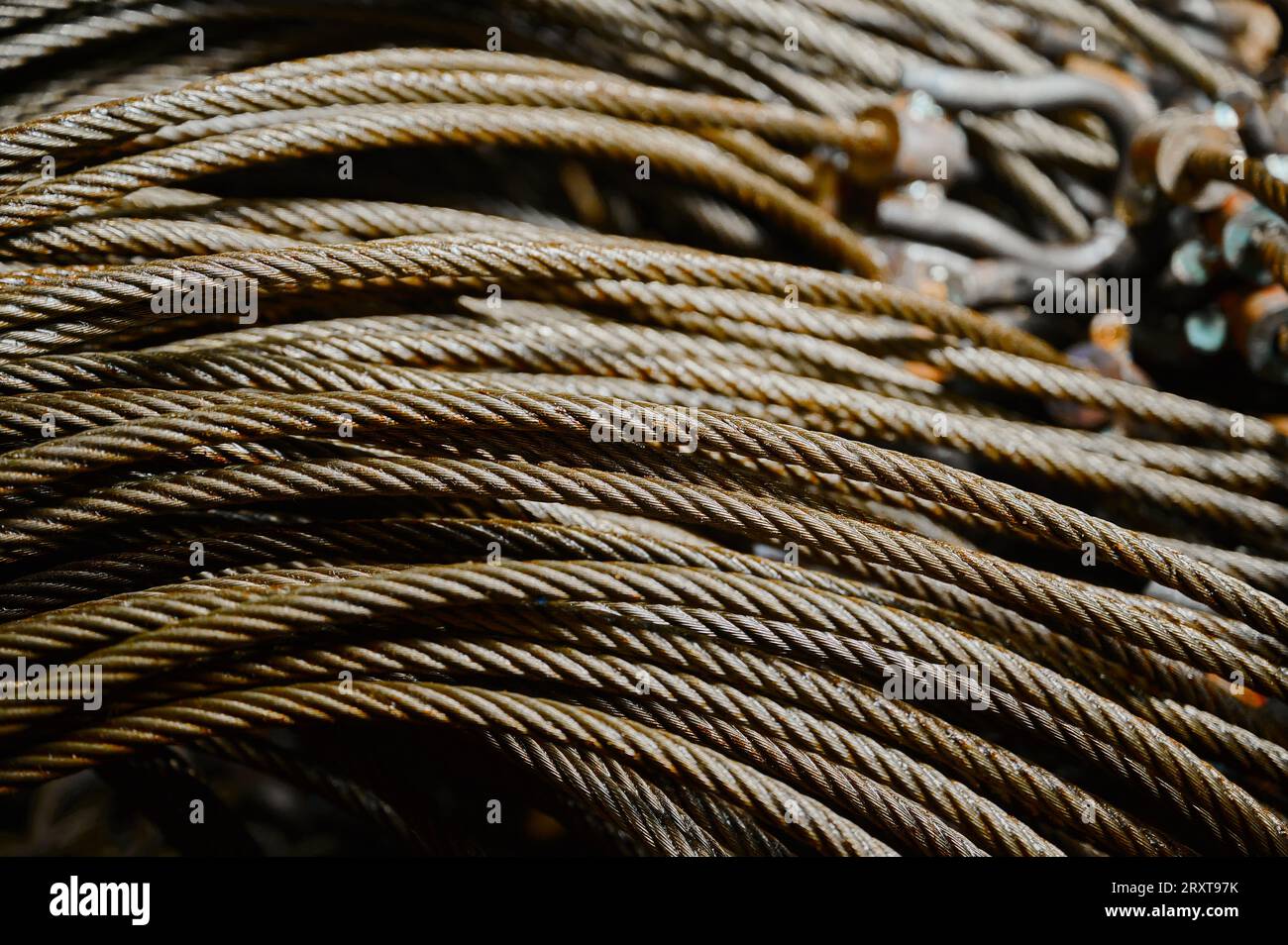 Twisted rope metal cables coiled in factory warehouse Stock Photo - Alamy