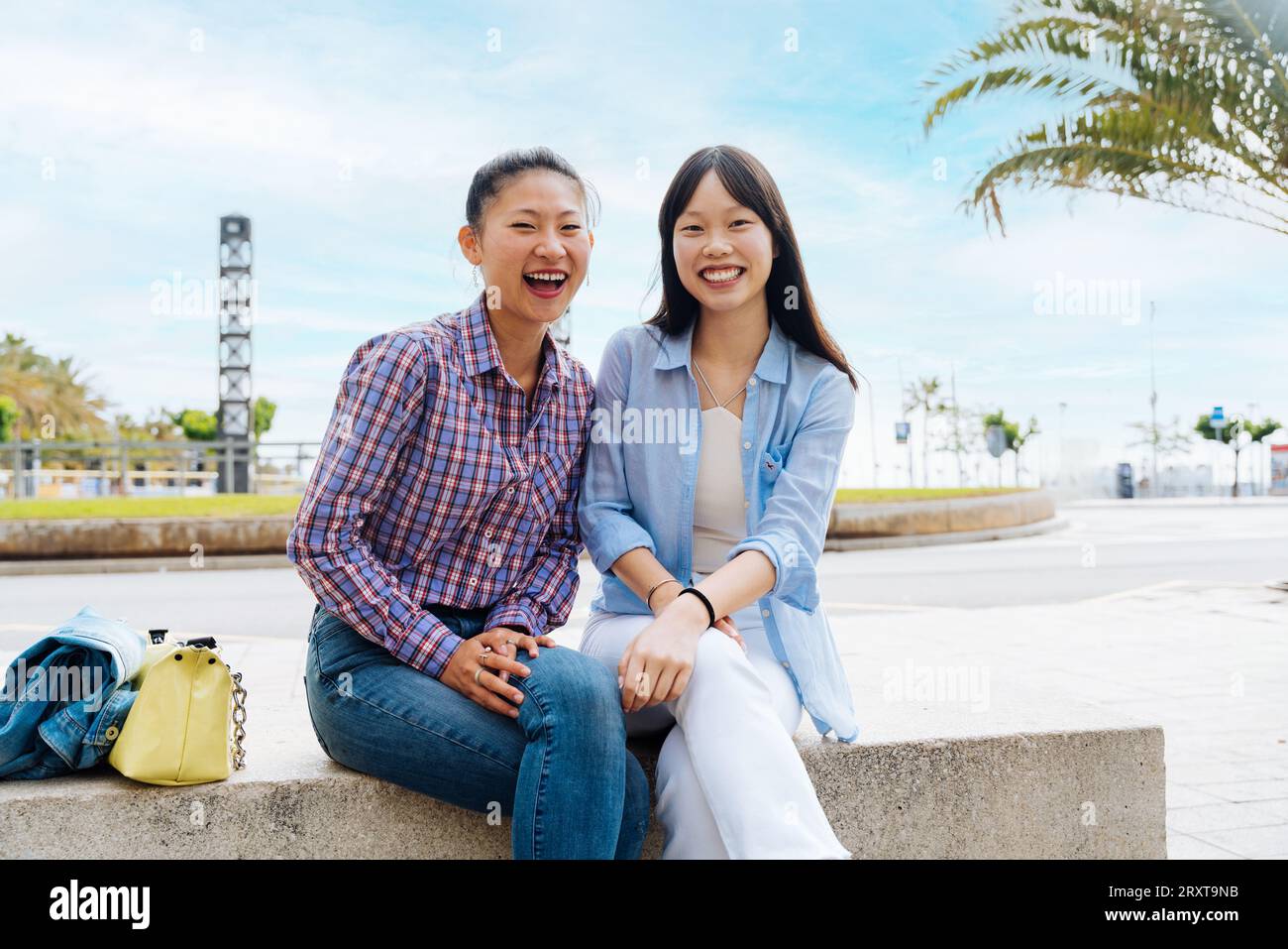 Happy beautiful chinese women friends bonding outdoors in the city ...