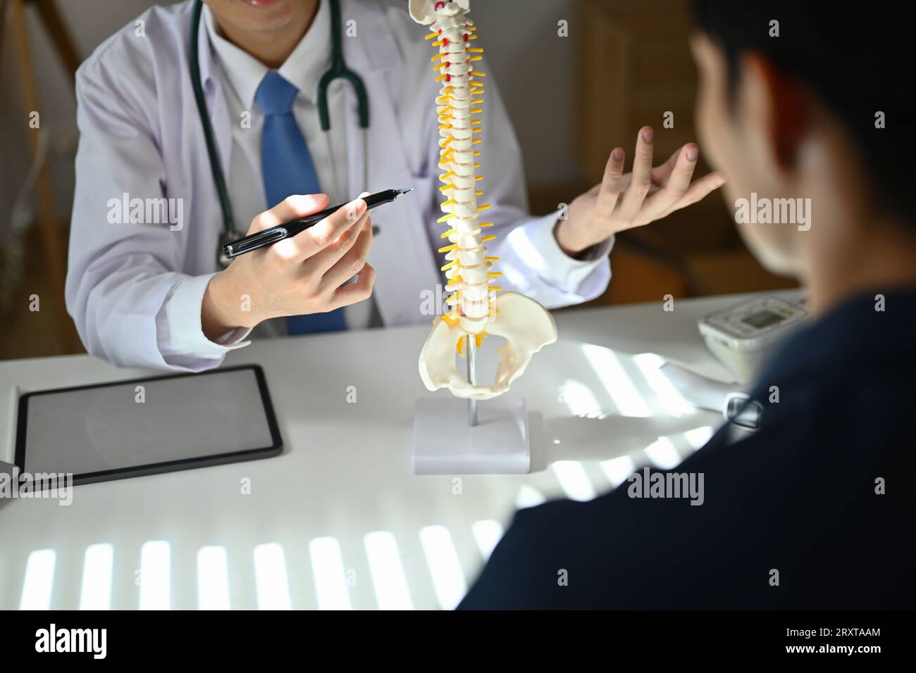 Experienced male orthopedist giving consultation about scoliosis or ...