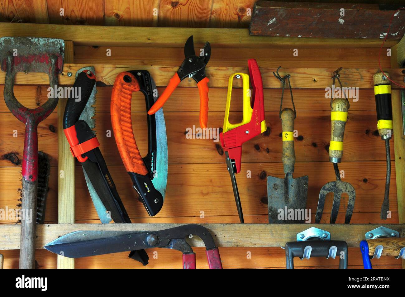 Gardening tools hanging in a well organised garden shed Stock Photo - Alamy