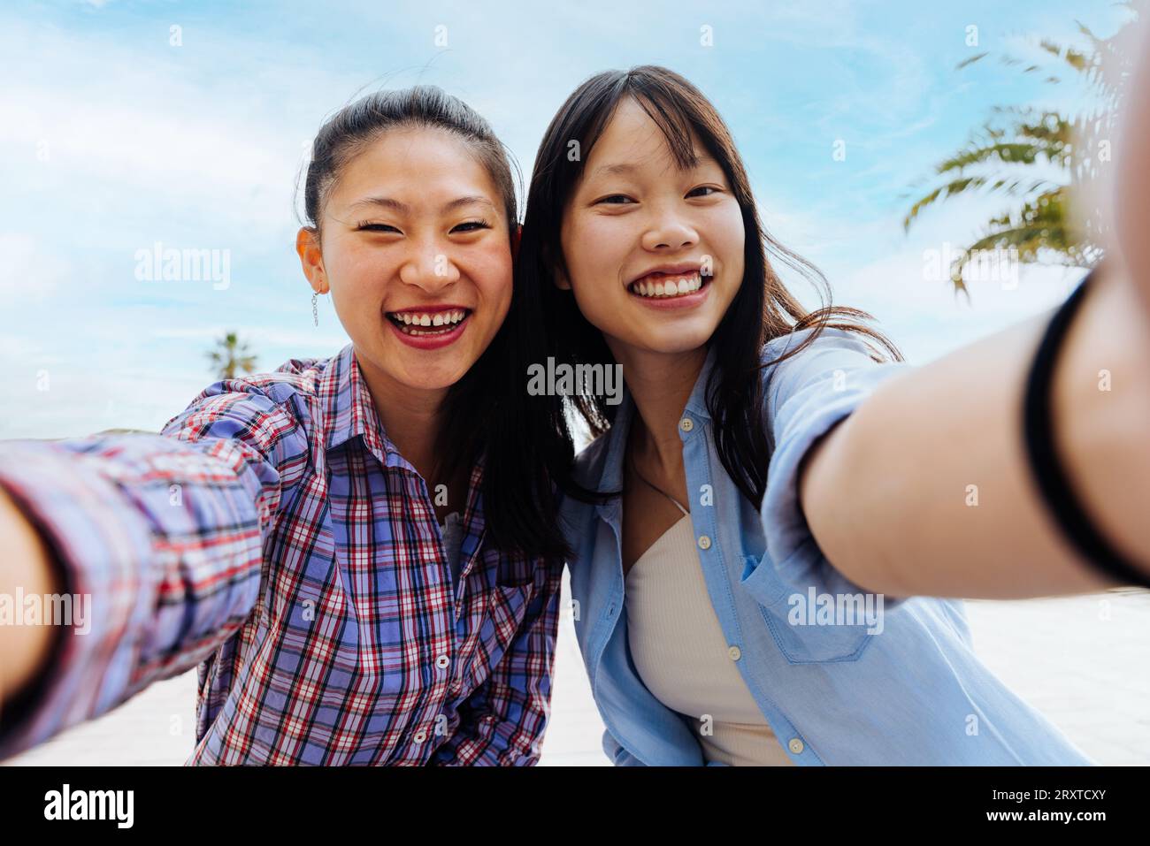 Happy beautiful chinese women friends bonding outdoors in the city ...