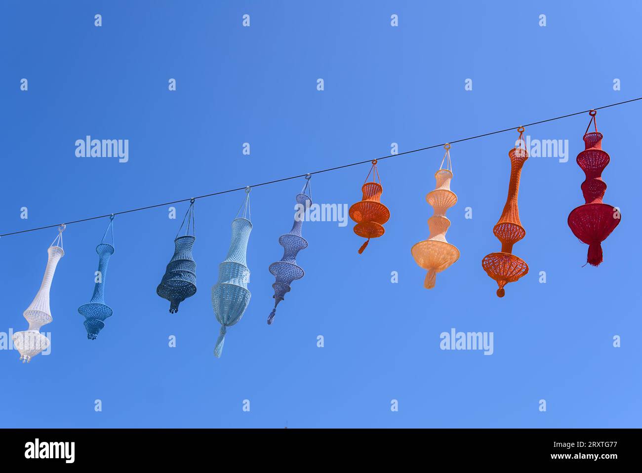 Colourful vibrant decorations hanged on a string with blue sky in the ...