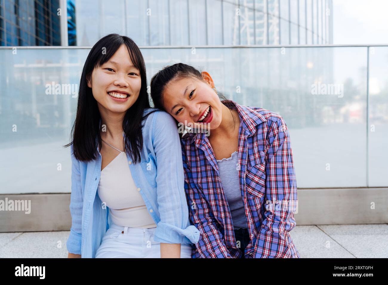Happy beautiful chinese women friends bonding outdoors in the city ...