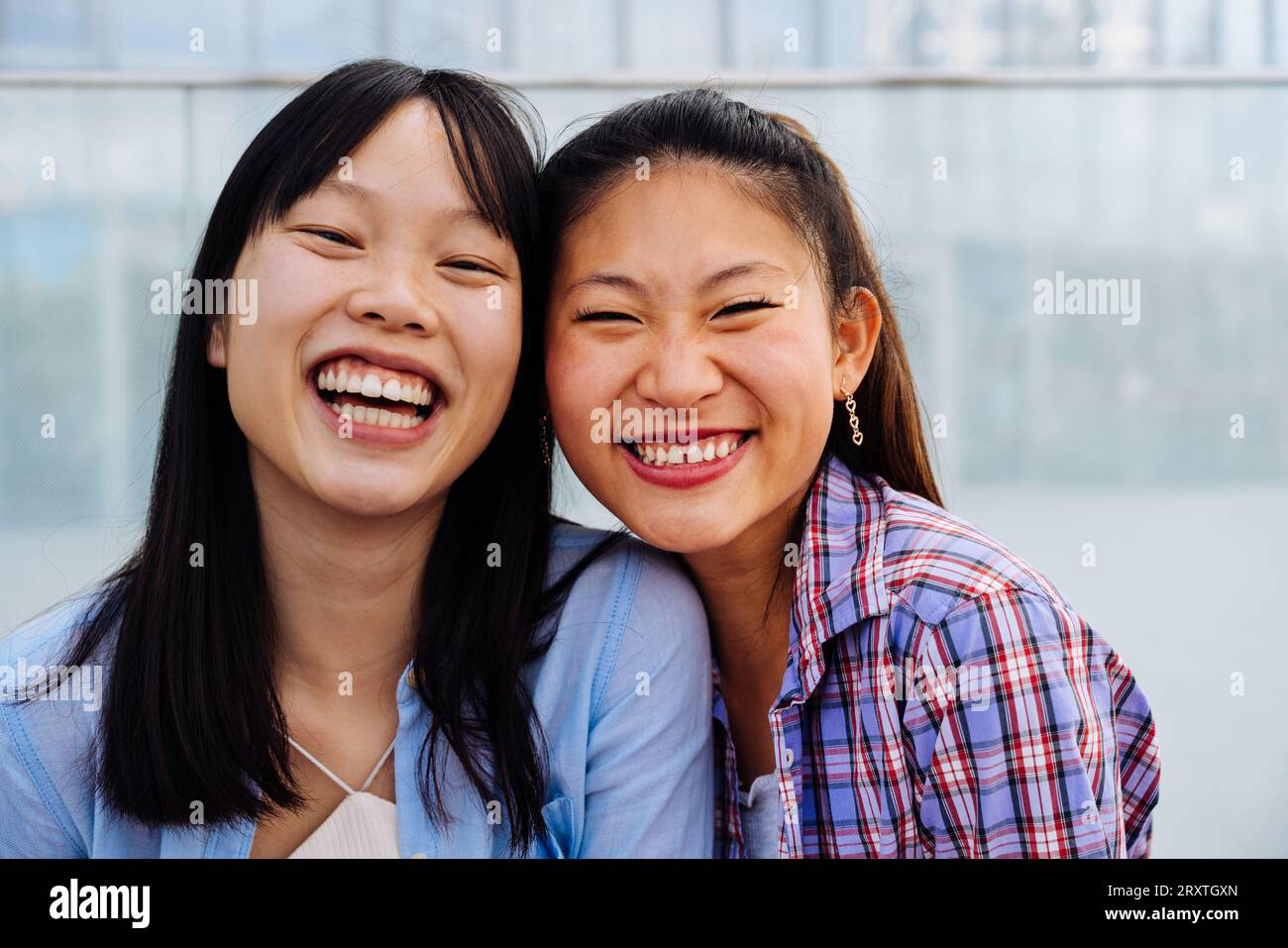 Happy beautiful chinese women friends bonding outdoors in the city ...