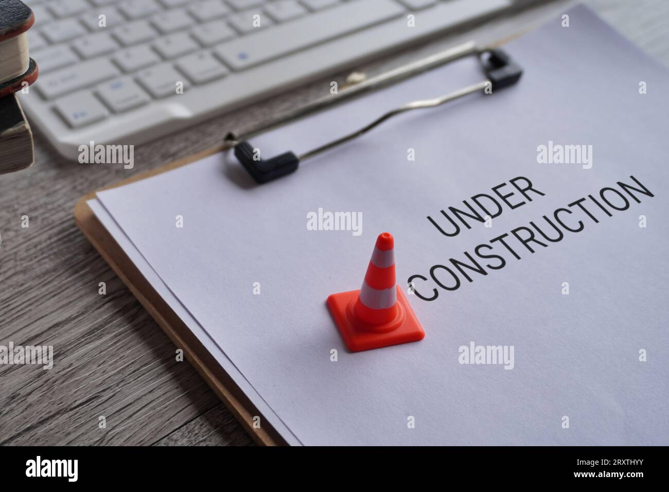 Closeup image of safety cone, wooden cube with text UNDER CONSTRUCTION ...