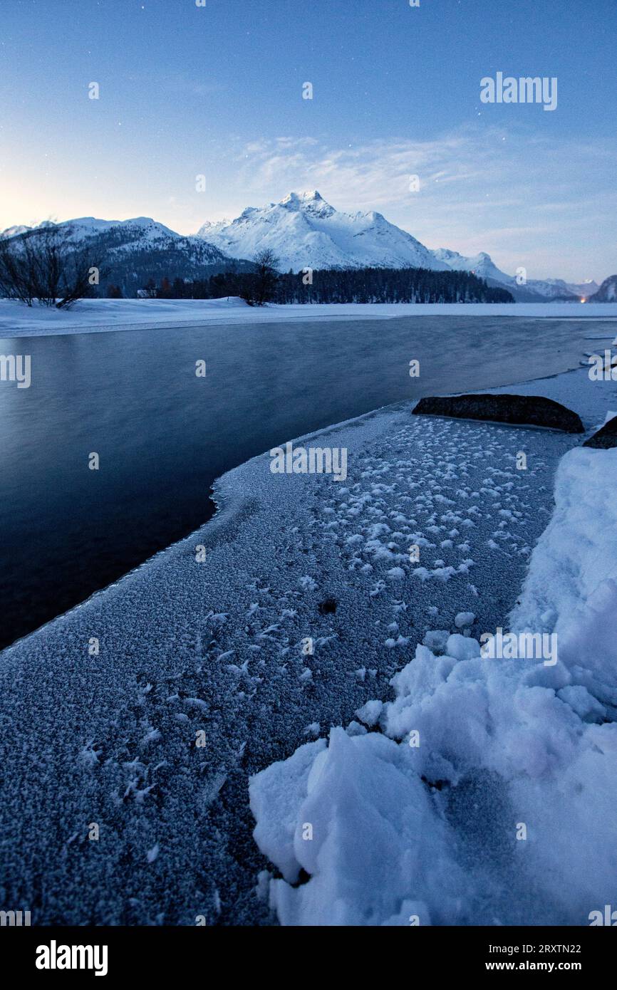 Winter sunrise over the frozen surface of Lake Sils in winter, Engadine ...
