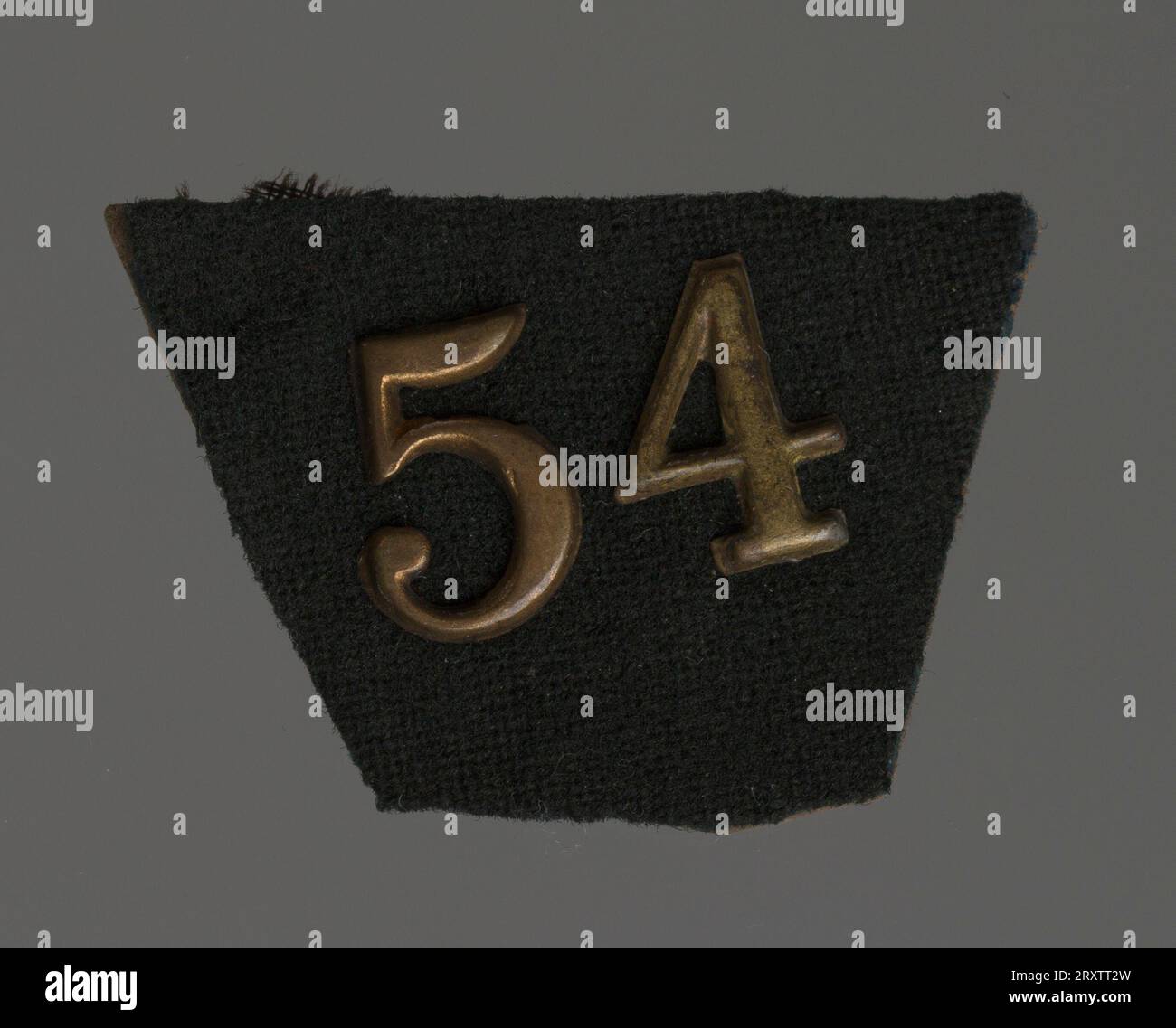 The brass number ¿54¿ is attached to a fabric-covered cardboard ...