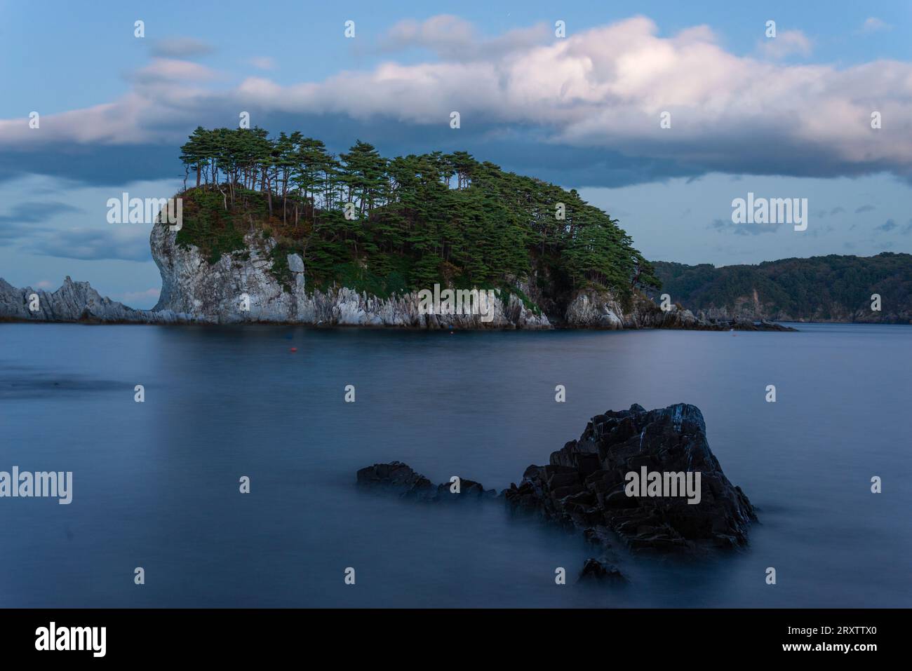 Long exposure of seascape with white cliff island with trees in ...
