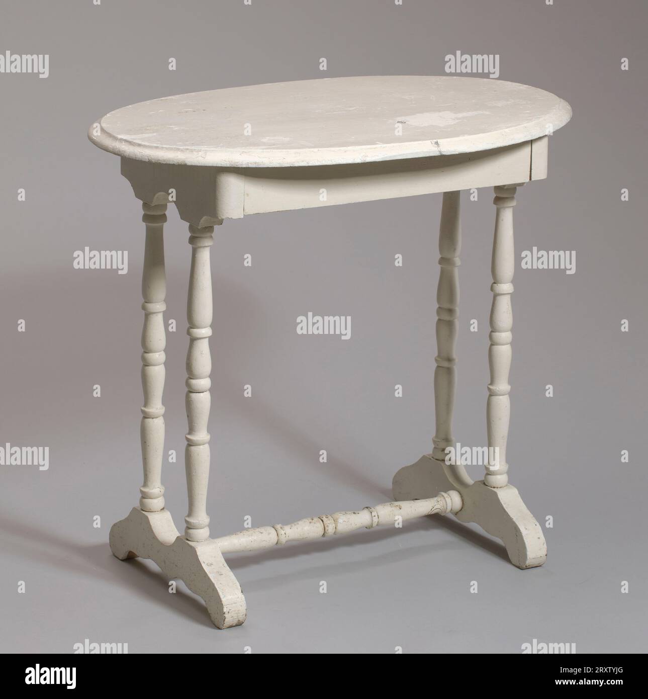 Small antique hall table painted white with an oval-shaped top attached ...
