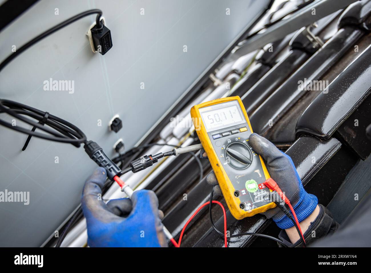 Solar panel on a roof being tested for its power output using a ...