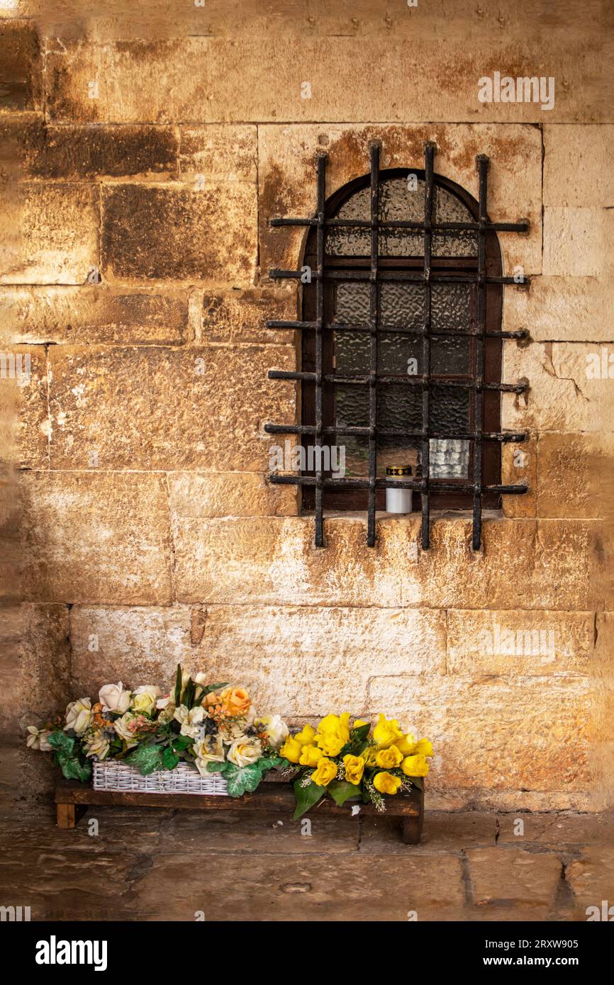 ancient semicircular window with bars in a Roman masonry wall with ...