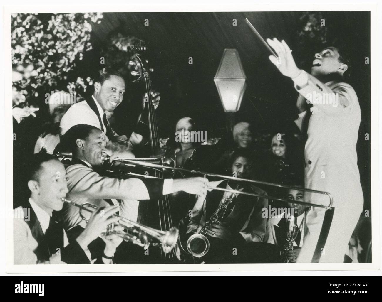 B & W photograph of Cab Calloway conducting band members. Calloway and ...