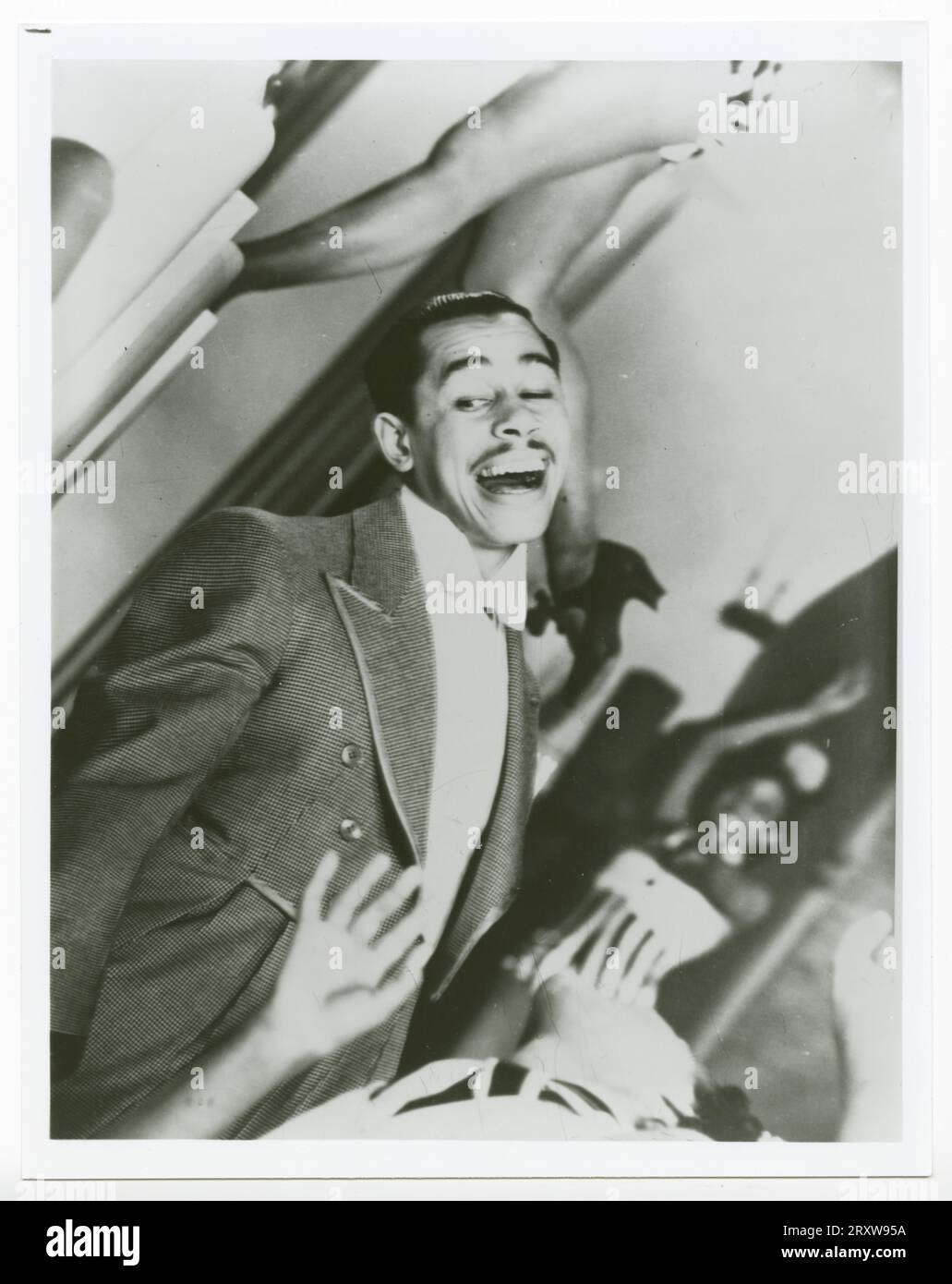 B & W photograph of Cab Calloway in a dark tuxedo. Calloway appears to ...