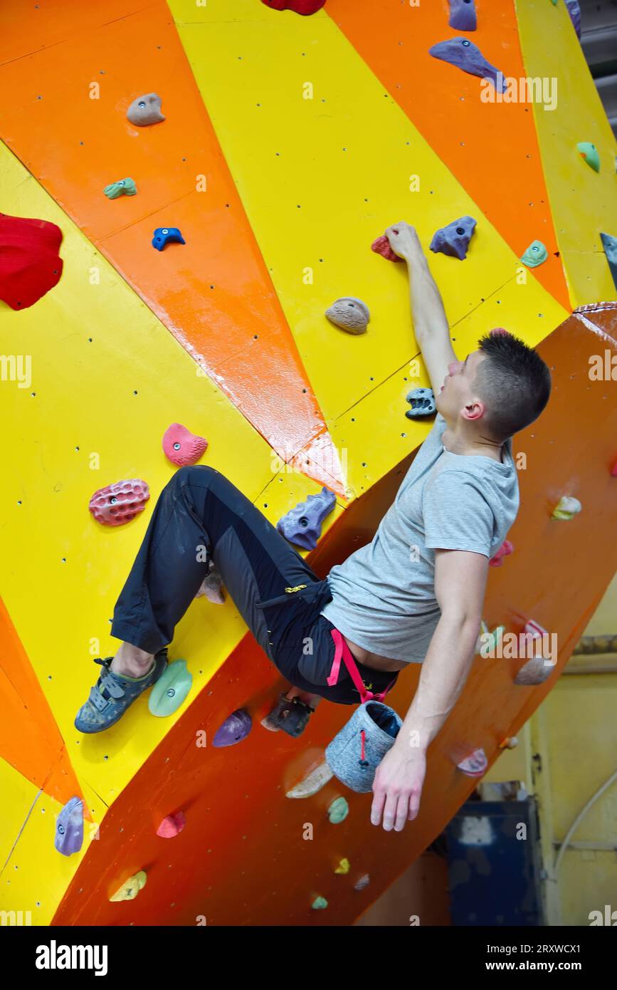Young man climbing up artificial hi-res stock photography and images ...