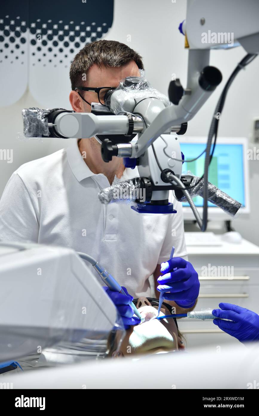 dentist examines patient's teeth with a dental microscope Stock Photo ...