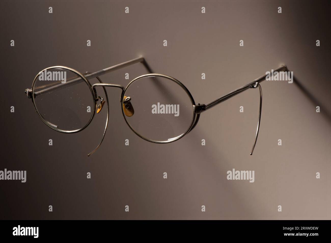 The glasses have round, circular lenses and thin metal temple bars made ...