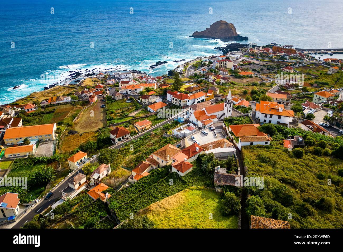 Aerial view of Porto Moniz, Portugal, stretching down the mountainsides ...