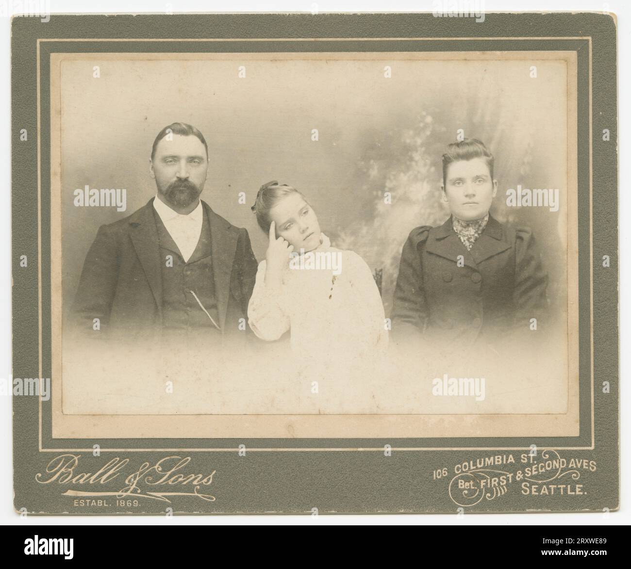 A black-and-white photograph of a woman, girl, and man photographed at ...