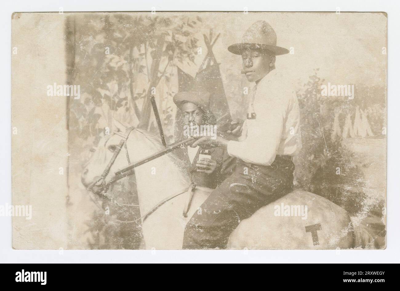 Postcard of two men posing in a Western scene in a photography studio ...