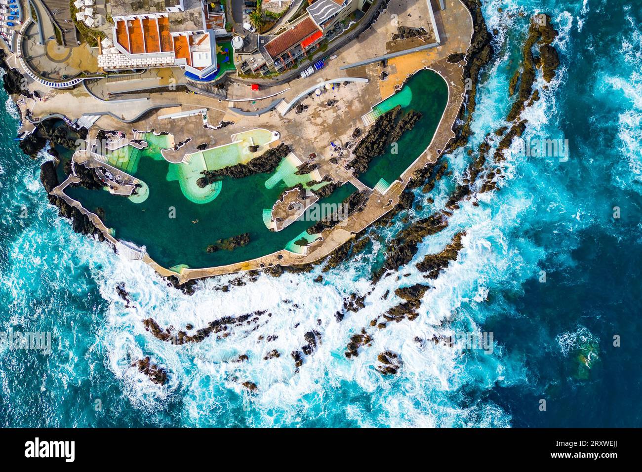 Bird's eye view of people swimming in the natural lava pools in Porto Moniz, Madeira, Portugal ...