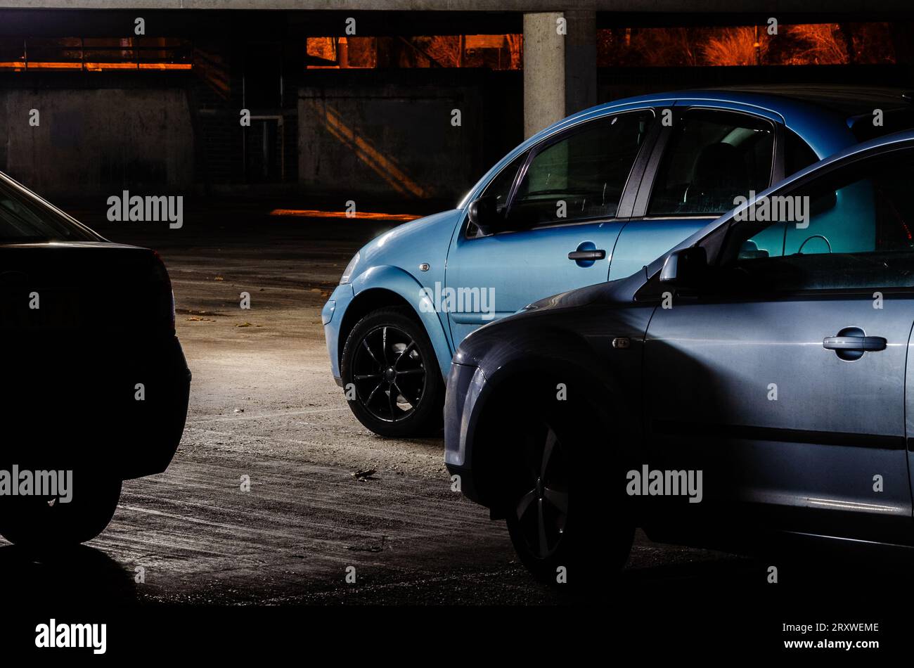 Underground car park at night. Dark with shadows. Cars parked Stock ...