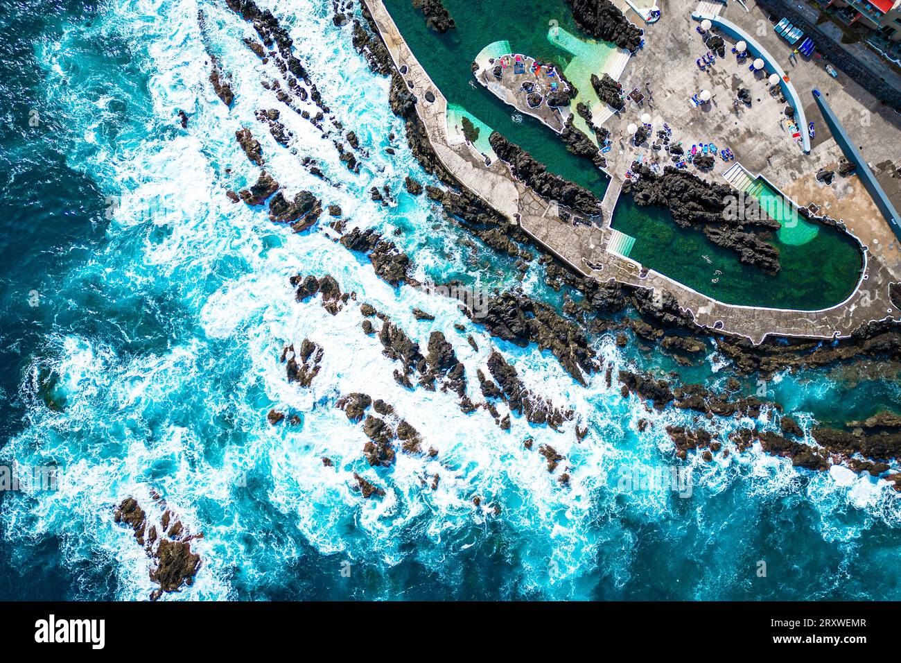 Fantastic bird's eye view of people swimming in the natural lava pools in Porto Moniz, Madeira ...
