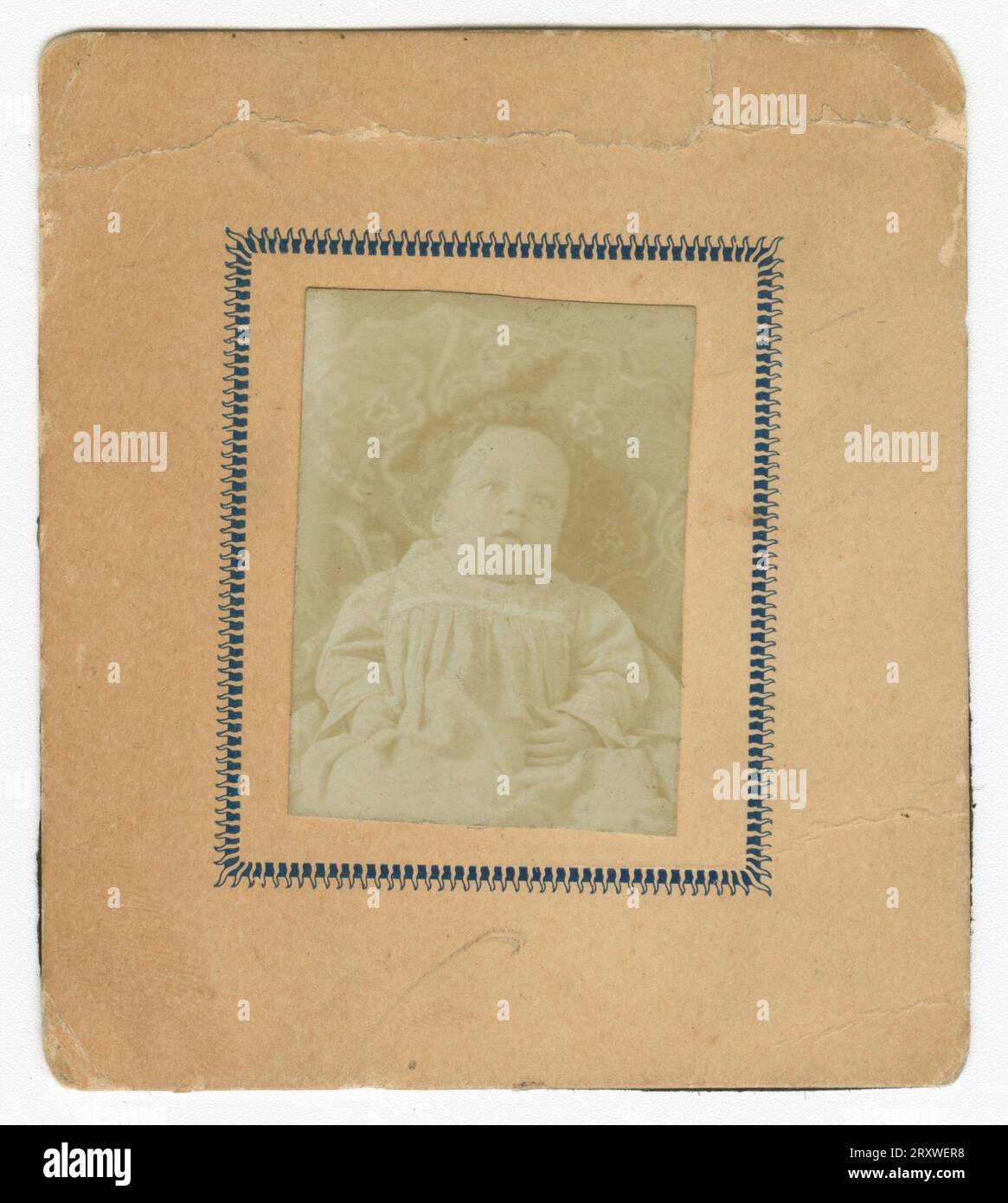 Photograph of a baby wearing dark colored clothing sitting in a chair ...