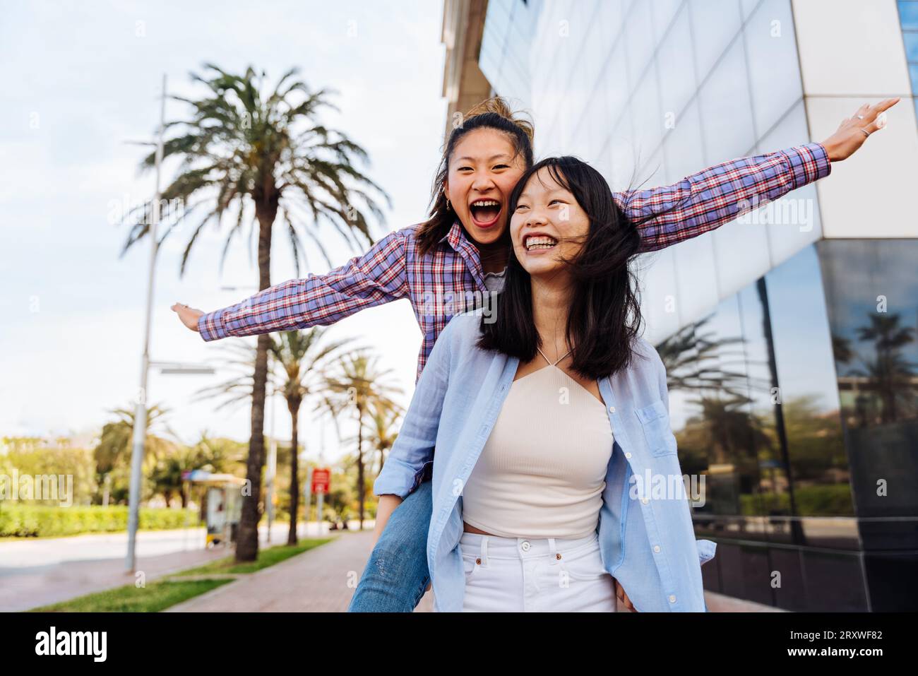 Happy beautiful chinese women friends bonding outdoors in the city ...