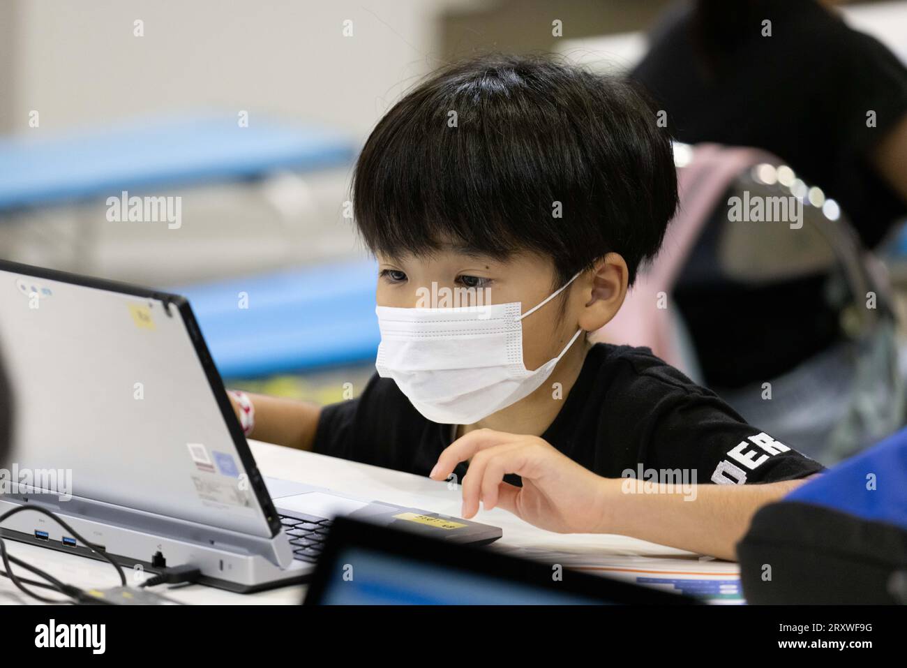 Participant of a video game programming workshop for kids solves an assigned programming task on ...