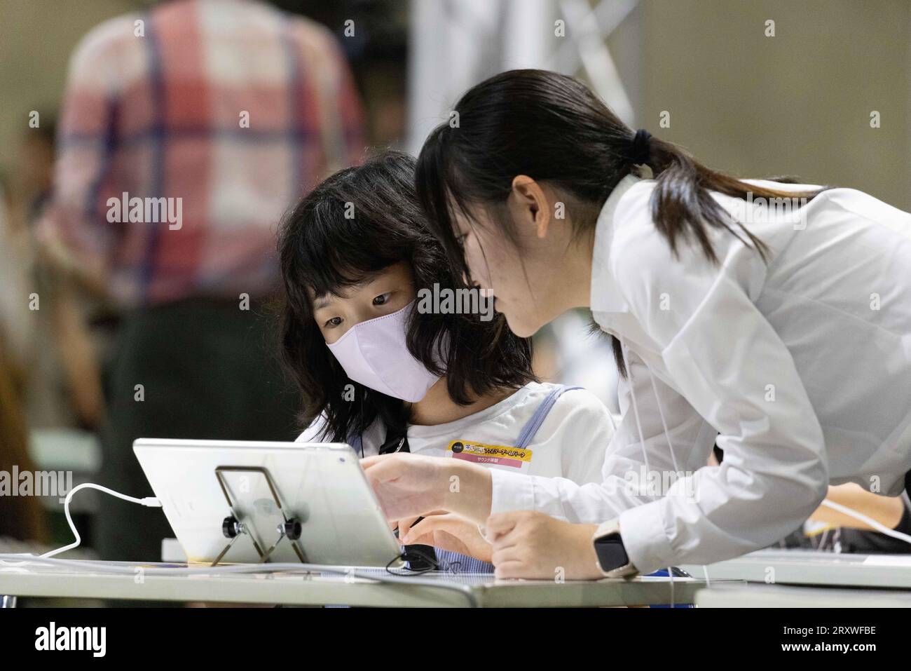 Participant of a video game programming workshop for kids receives help ...