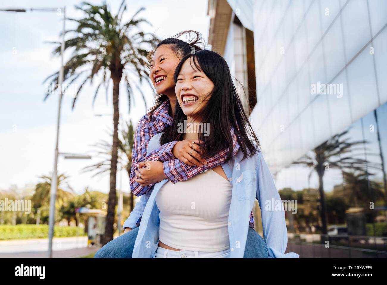 Happy beautiful chinese women friends bonding outdoors in the city ...