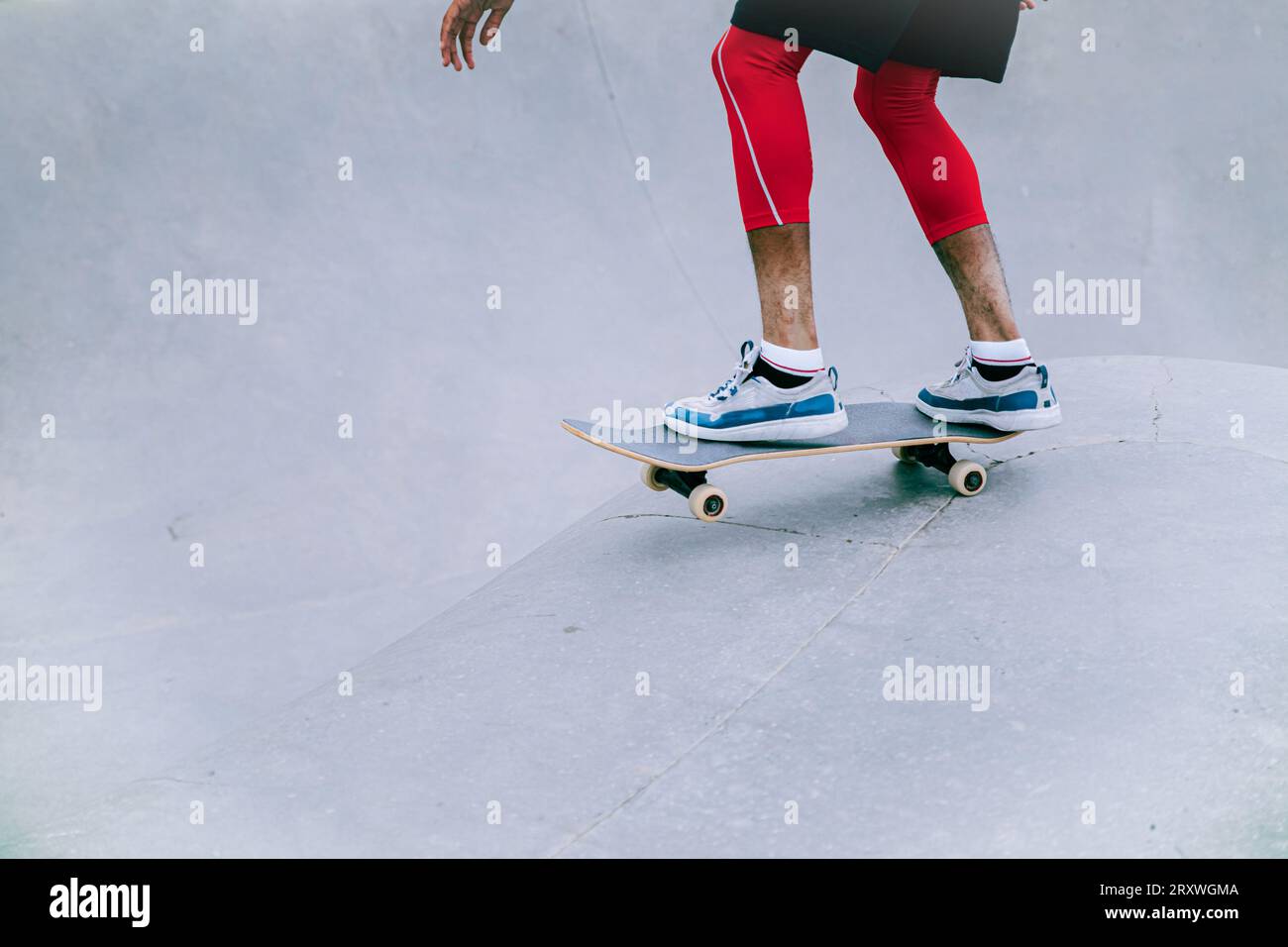 The skater rides through the bowl at the skatepark, close-up on the ...