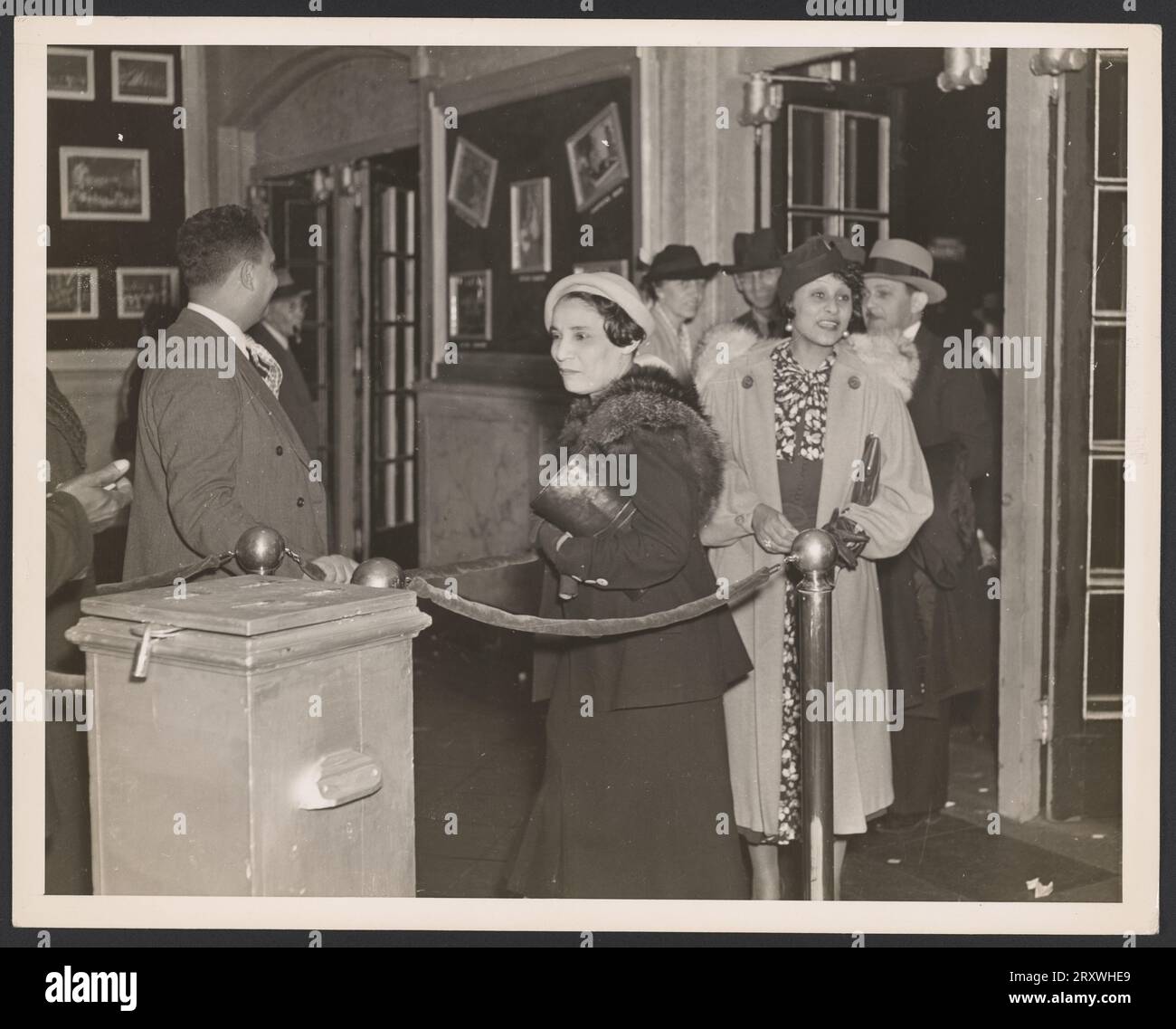 Gelatin silver print of a line of guests arriving behind a velvet rope ...