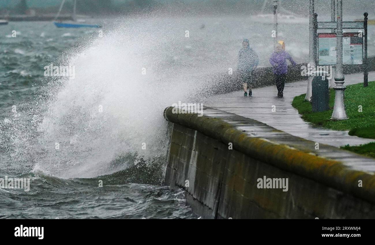 People walk along the Clontarf promenade, Dublin, as Storm Agnes lands ...