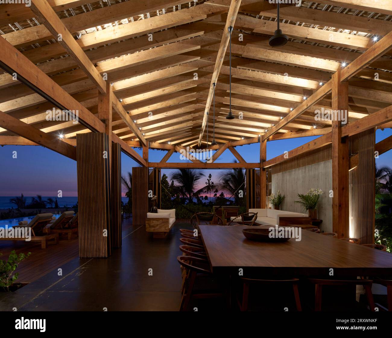 Dusk view with palapa roof ceiling and sunset. Casa Leria, Puerto Escindido, Mexico. Architect ...