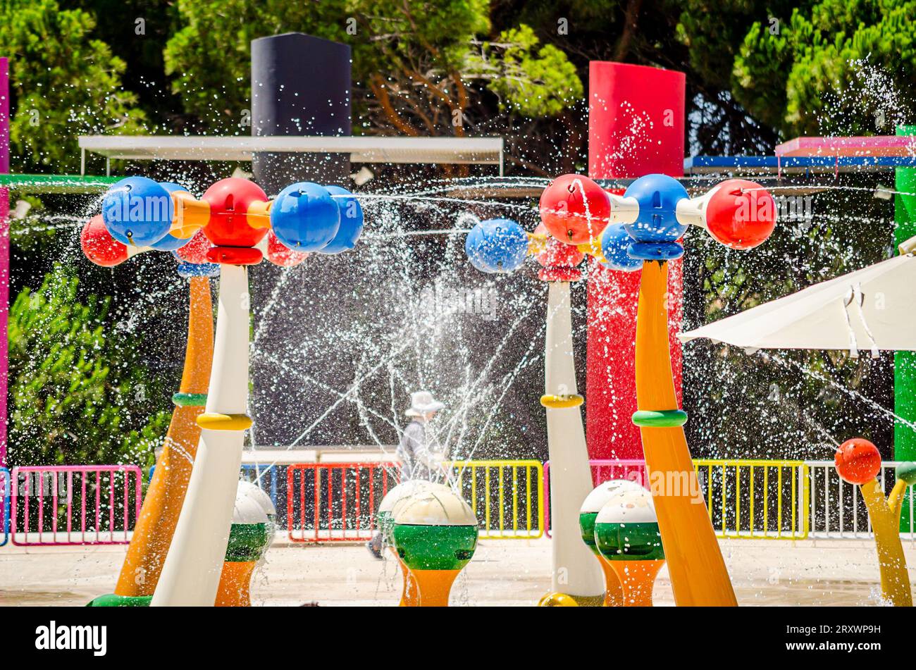 Colorful Water Splashing Pad in an Aqua Park. Rotating Fountain Shoots ...