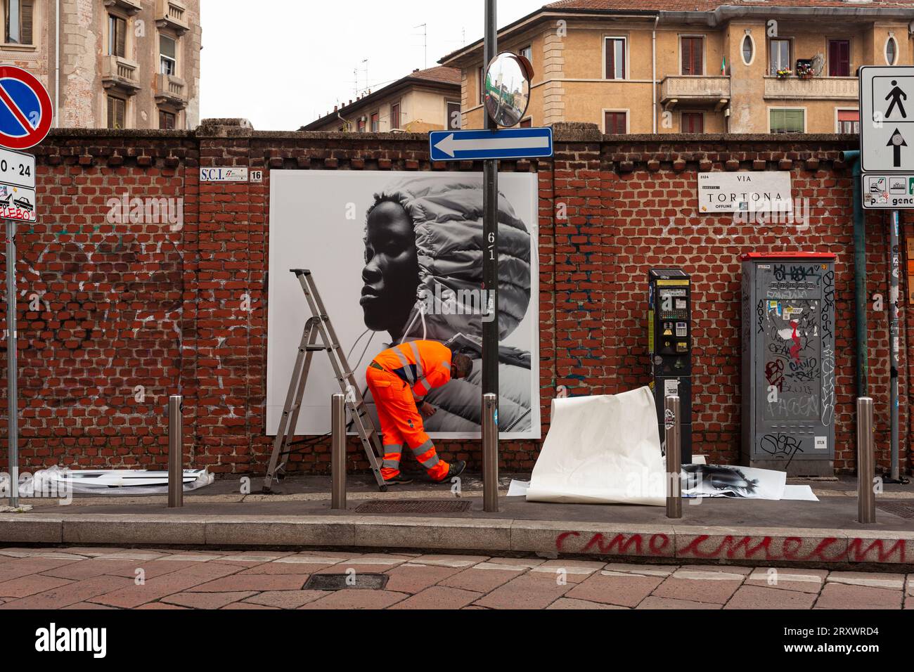 Woman putting up advertising poster hi-res stock photography and images ...