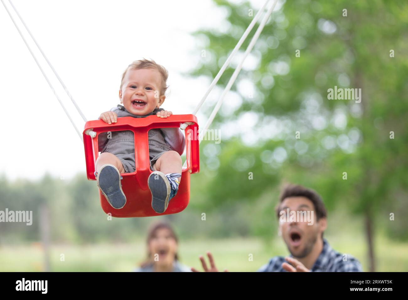 parents panic as baby swings high in the park Stock Photo - Alamy