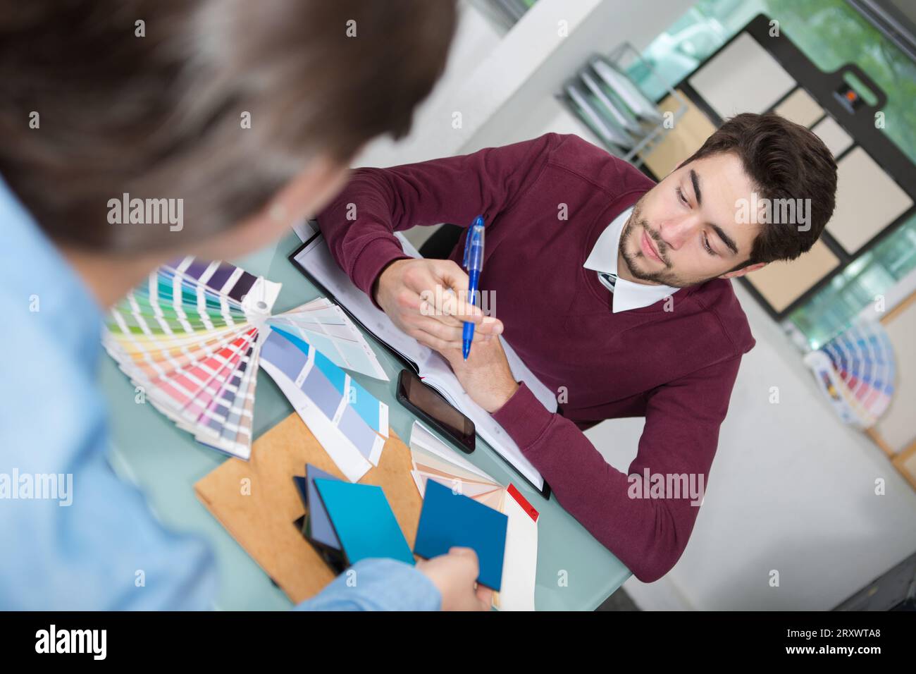male interior designer with clients at office choosing colors Stock ...