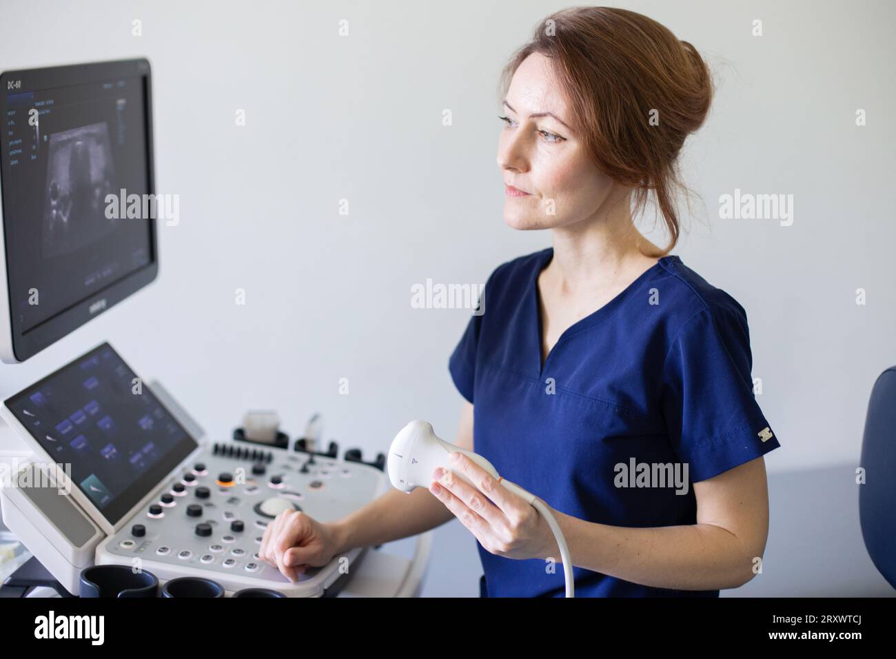 Doctor woman doing ultrasound scanning diagnostic of thyroid gland ...