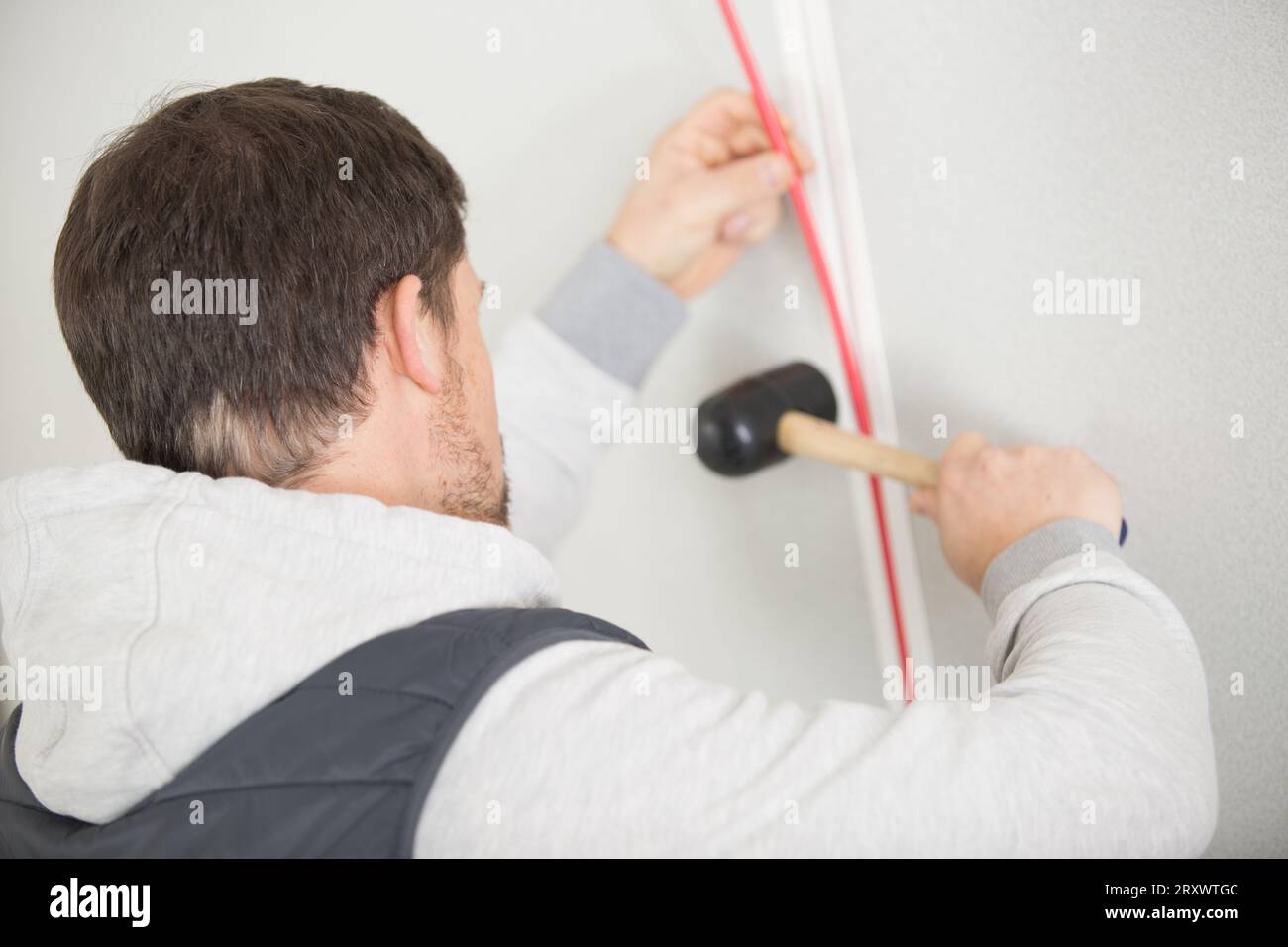 builder knocking wall with hammer Stock Photo - Alamy