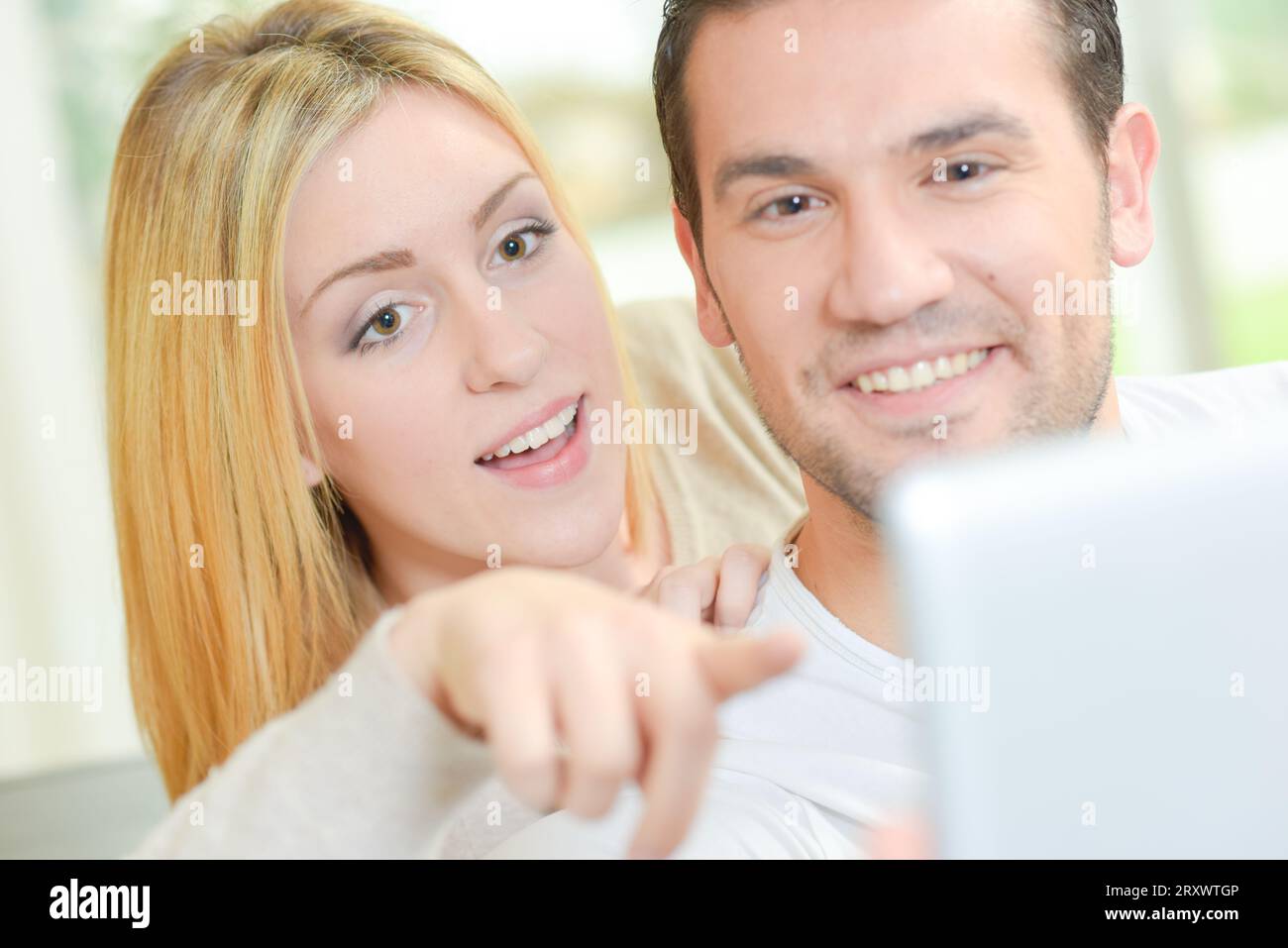Couple looking at computer, pointing with surprise Stock Photo - Alamy