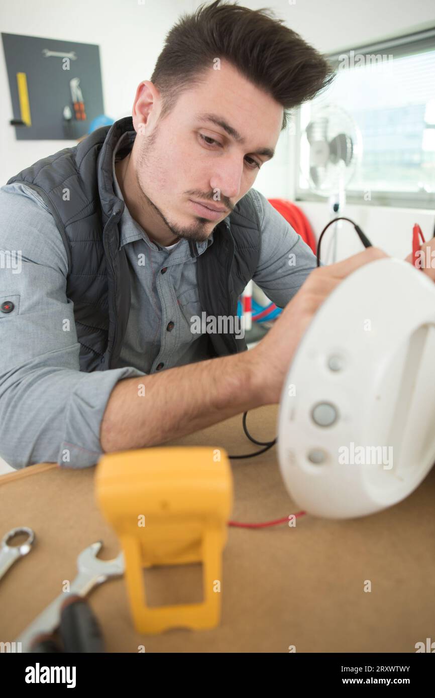 technician testing faulty appliance with a multimeter Stock Photo - Alamy