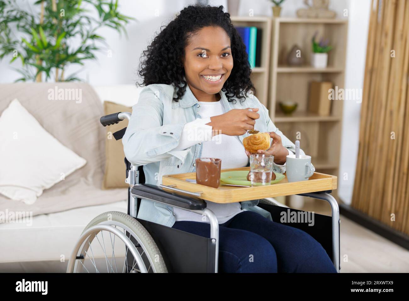 disabled woman in wheelchair eating croissants Stock Photo - Alamy