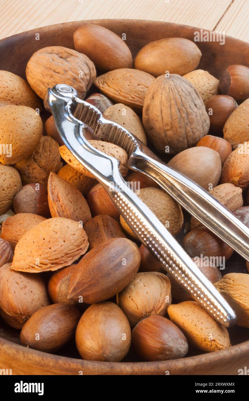 Wooden bowl containing a mixture of nuts with nut cracker Stock Photo ...