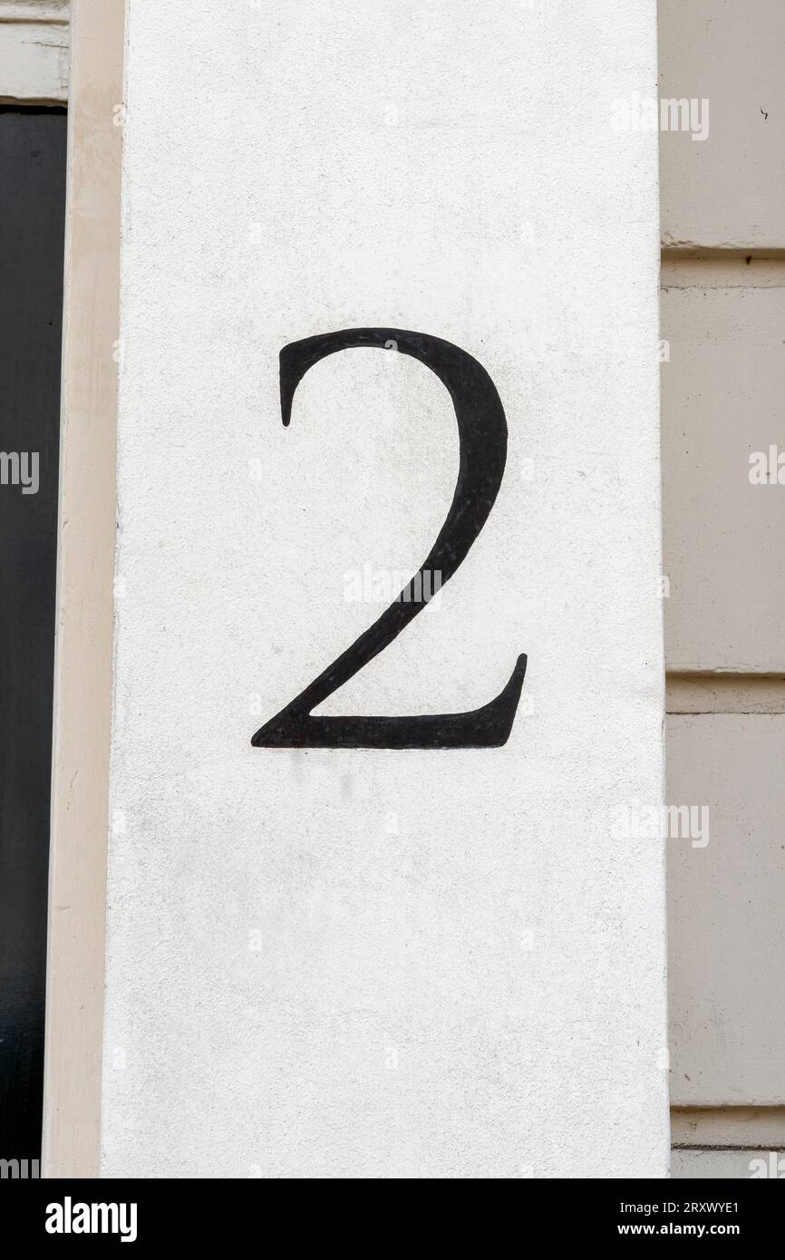 Number two door number hand painted in black on white wall Stock Photo ...